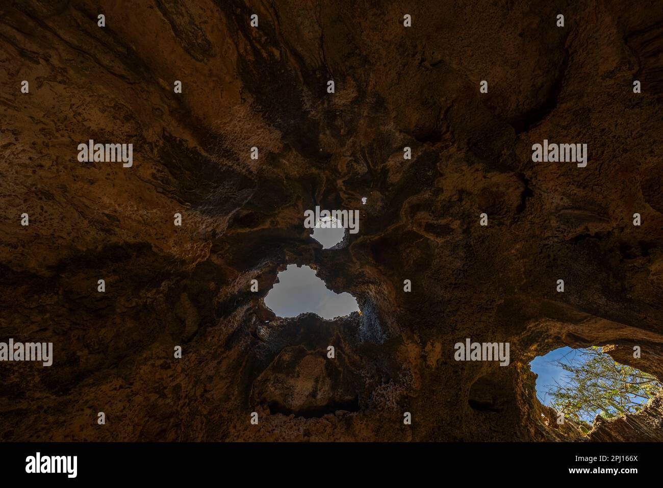 View of blue sky and clouds through natural openings in top of ...