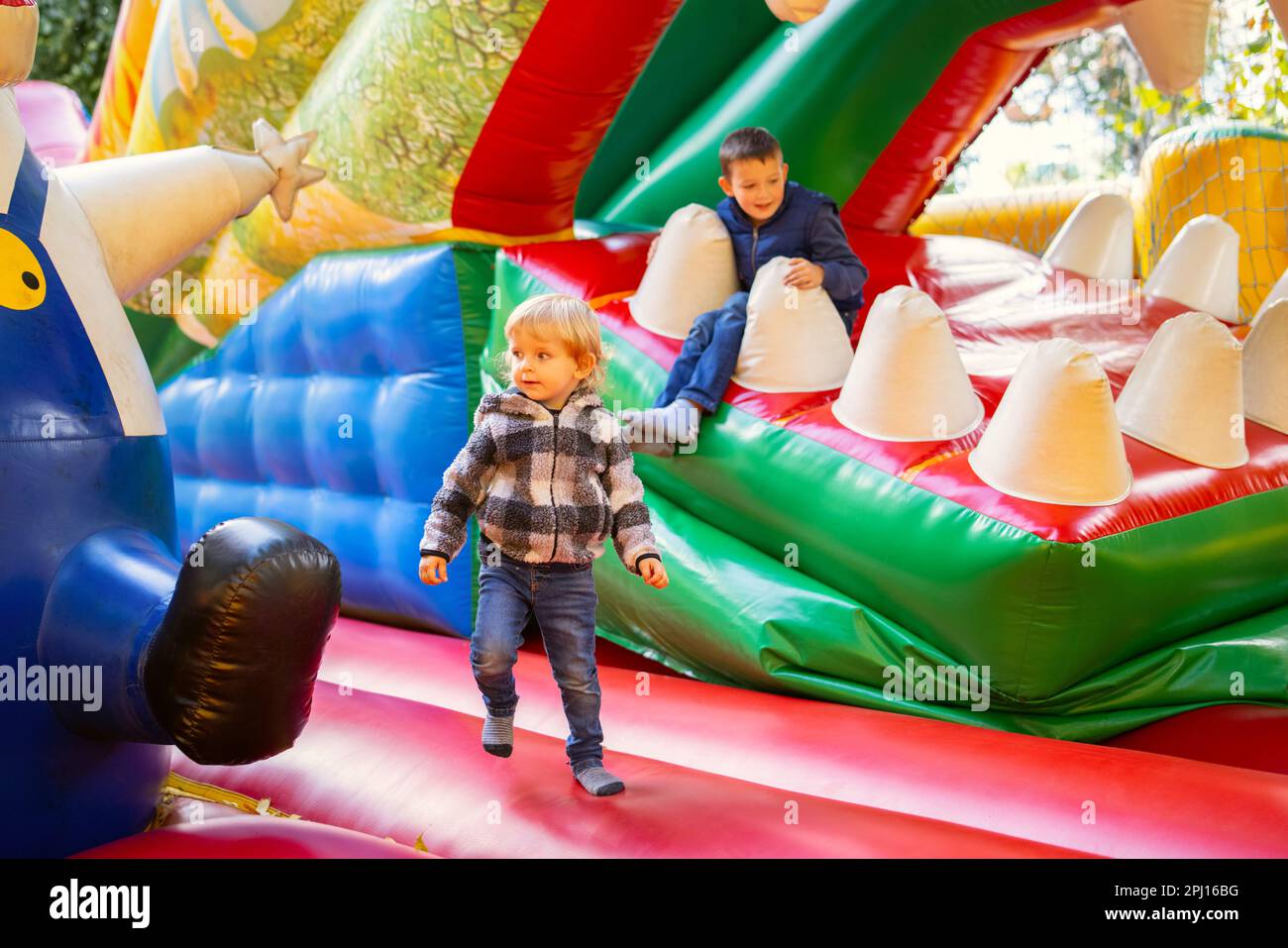 Happy kids having fun on colorful inflatable attraction playground ...