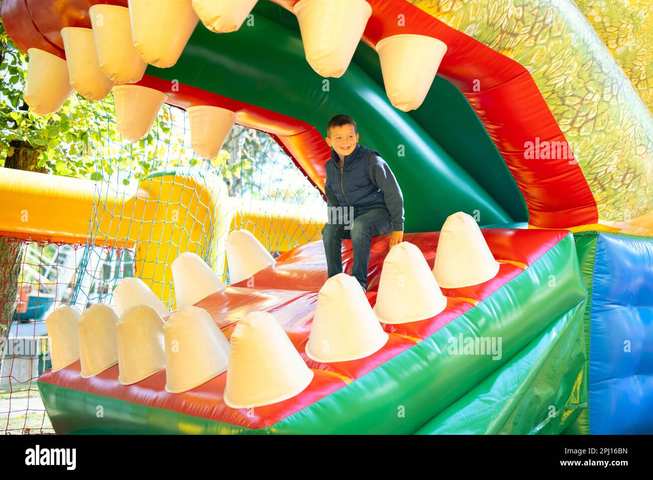 Happy boy having a lots of fun on a colorful inflate castle Stock Photo ...