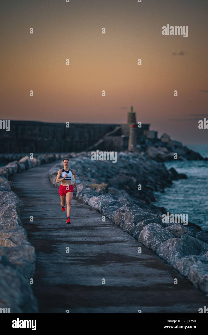 Woman running in a lighthouse,in a beautiful setting with sunset Stock ...