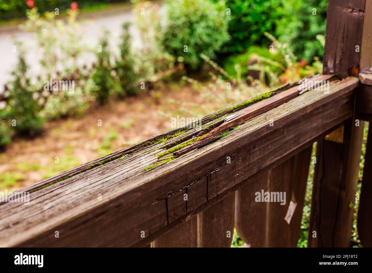 Old wooden terrace, damaged old wooden railing in a garden, weather ...