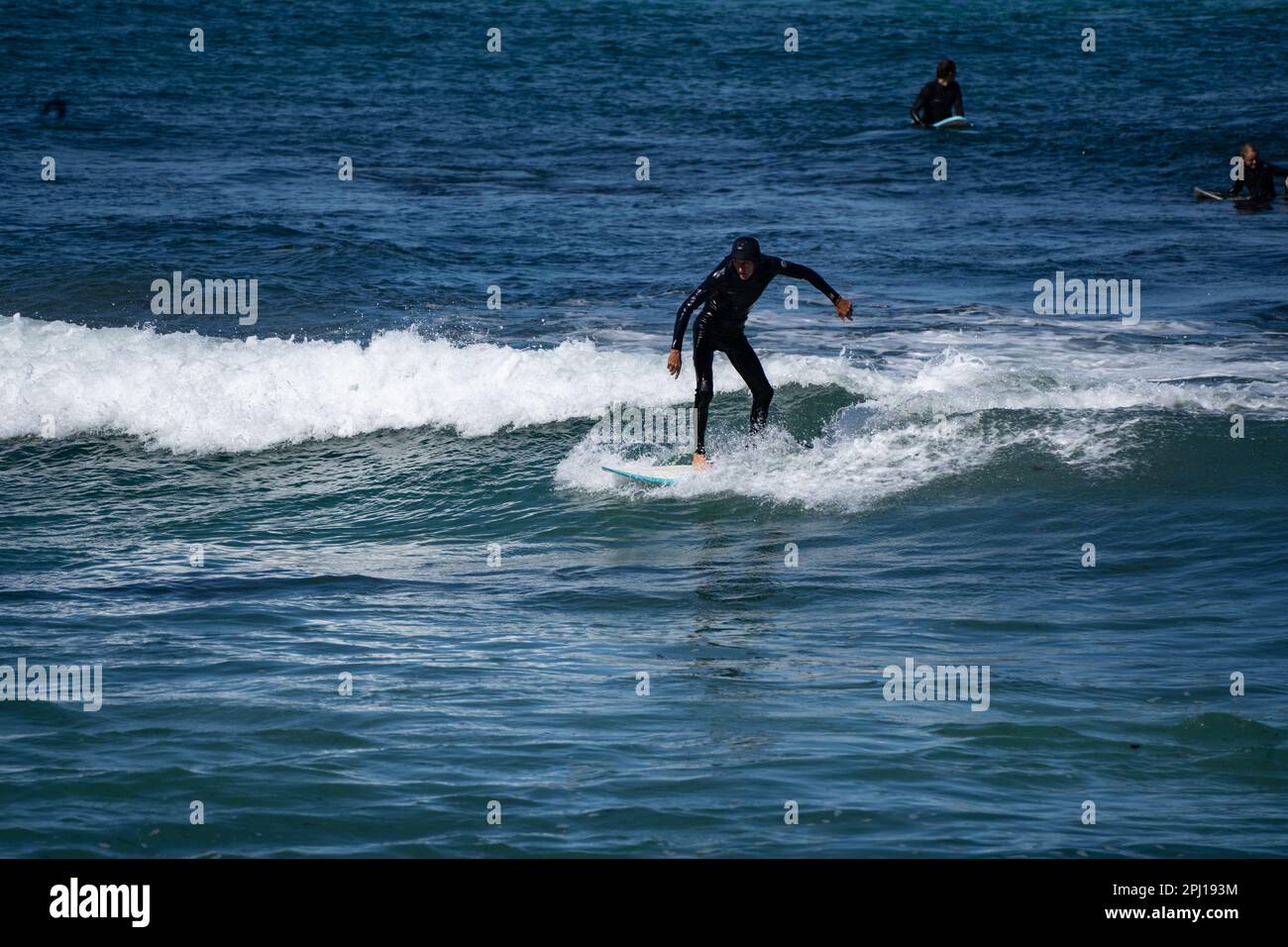 Practising surfing the waves on a quiet day at Yanchep Beach, Perth ...