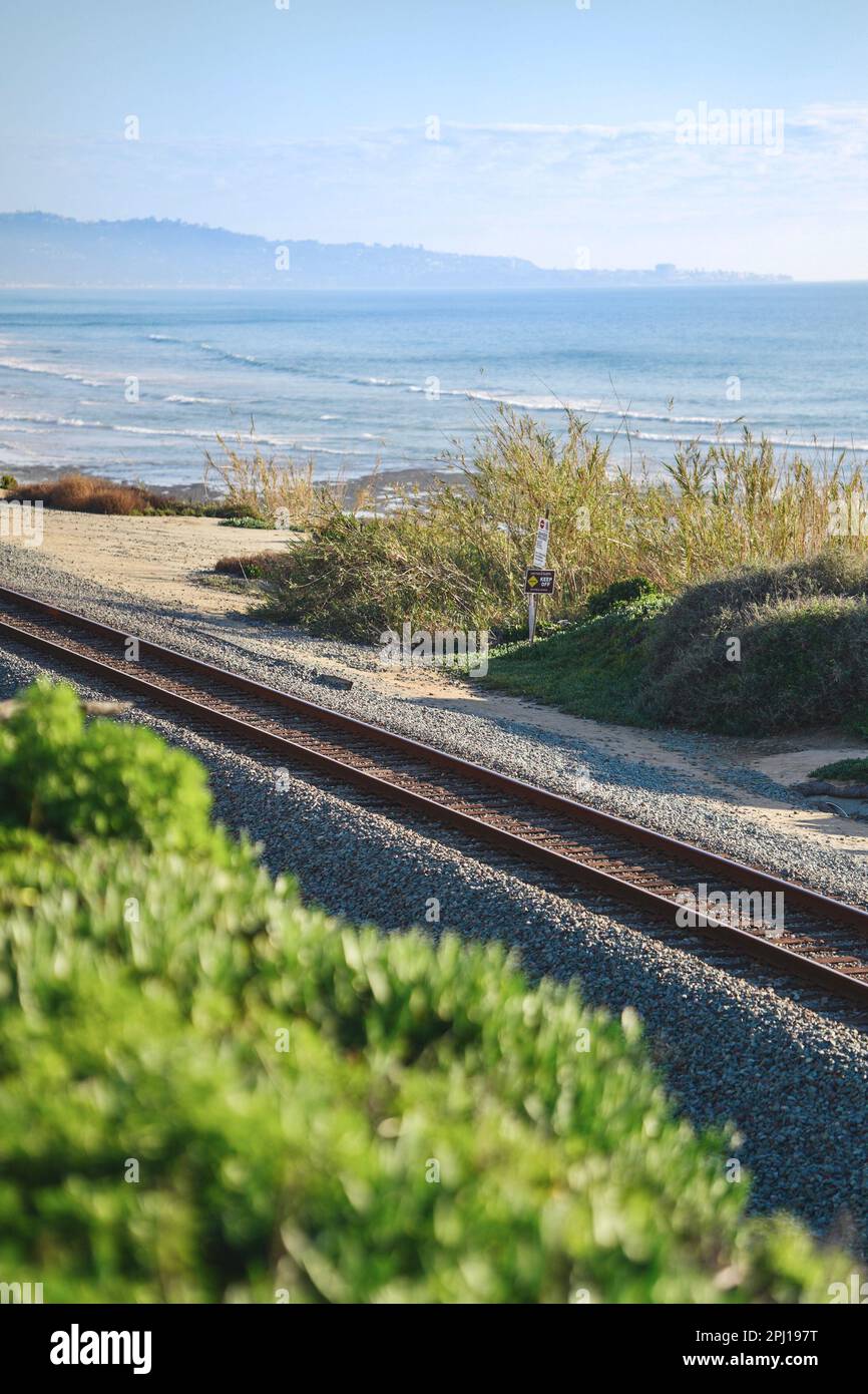 A railway line positioned alongside a vast expanse of ocean Stock Photo ...