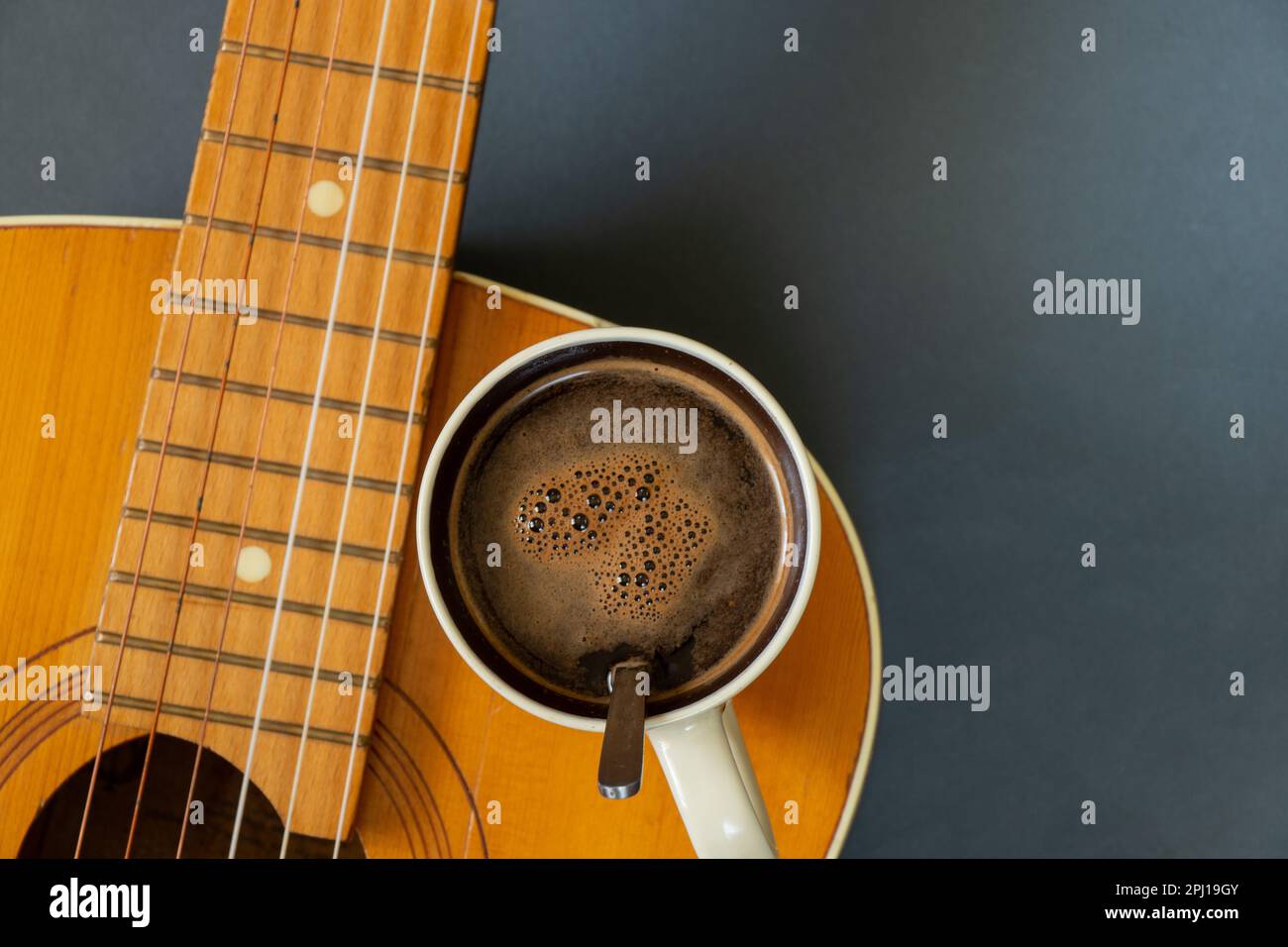 wooden guitar and a cup of coffee on a dark background Stock Photo - Alamy