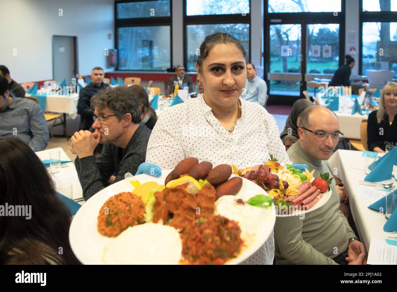 Berlin, Germany. 30th Mar, 2023. A woman serves food at the House of ...