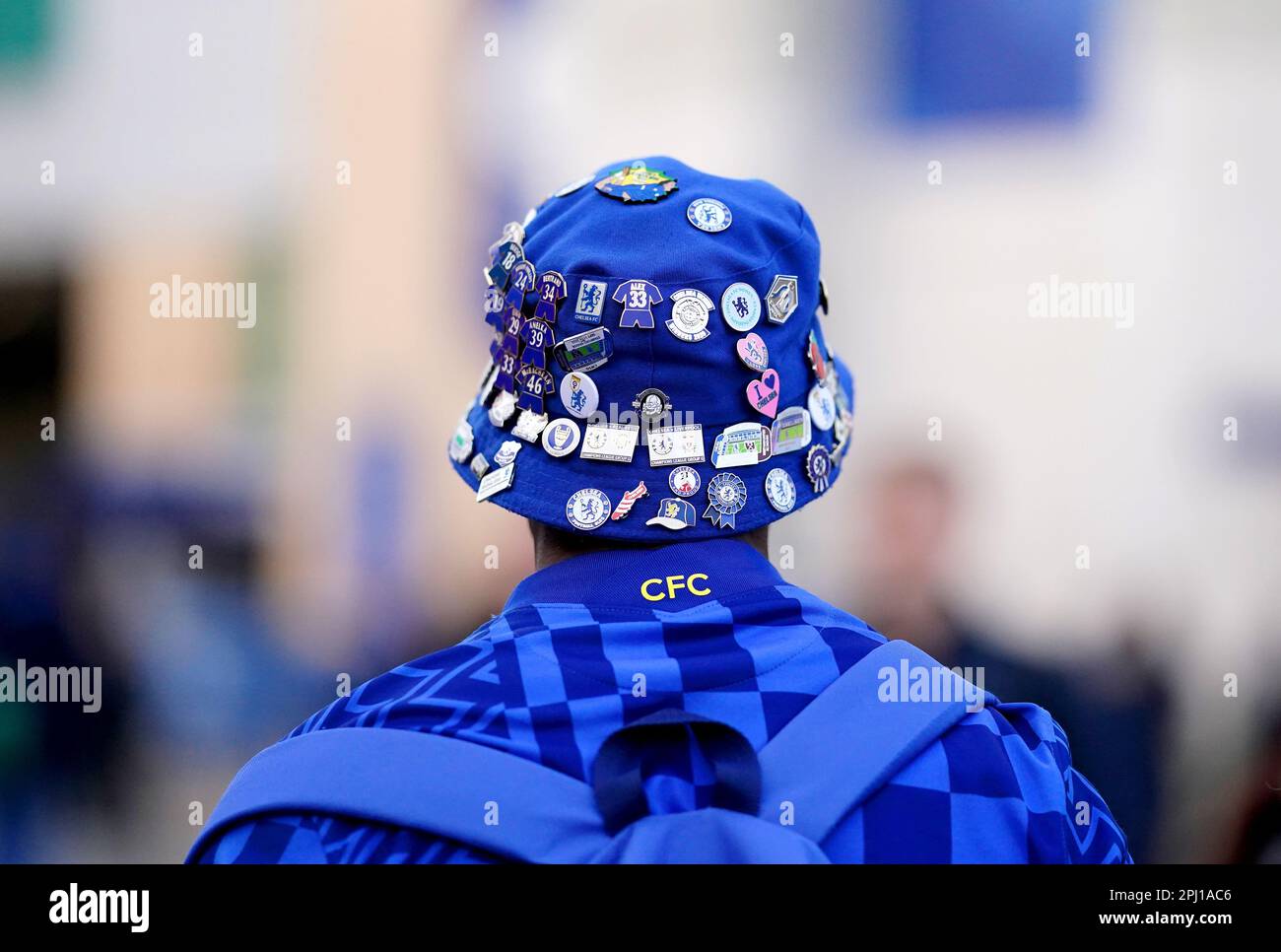 A Chelsea fan wearing a hat covered in badges arrives ahead of the UEFA ...