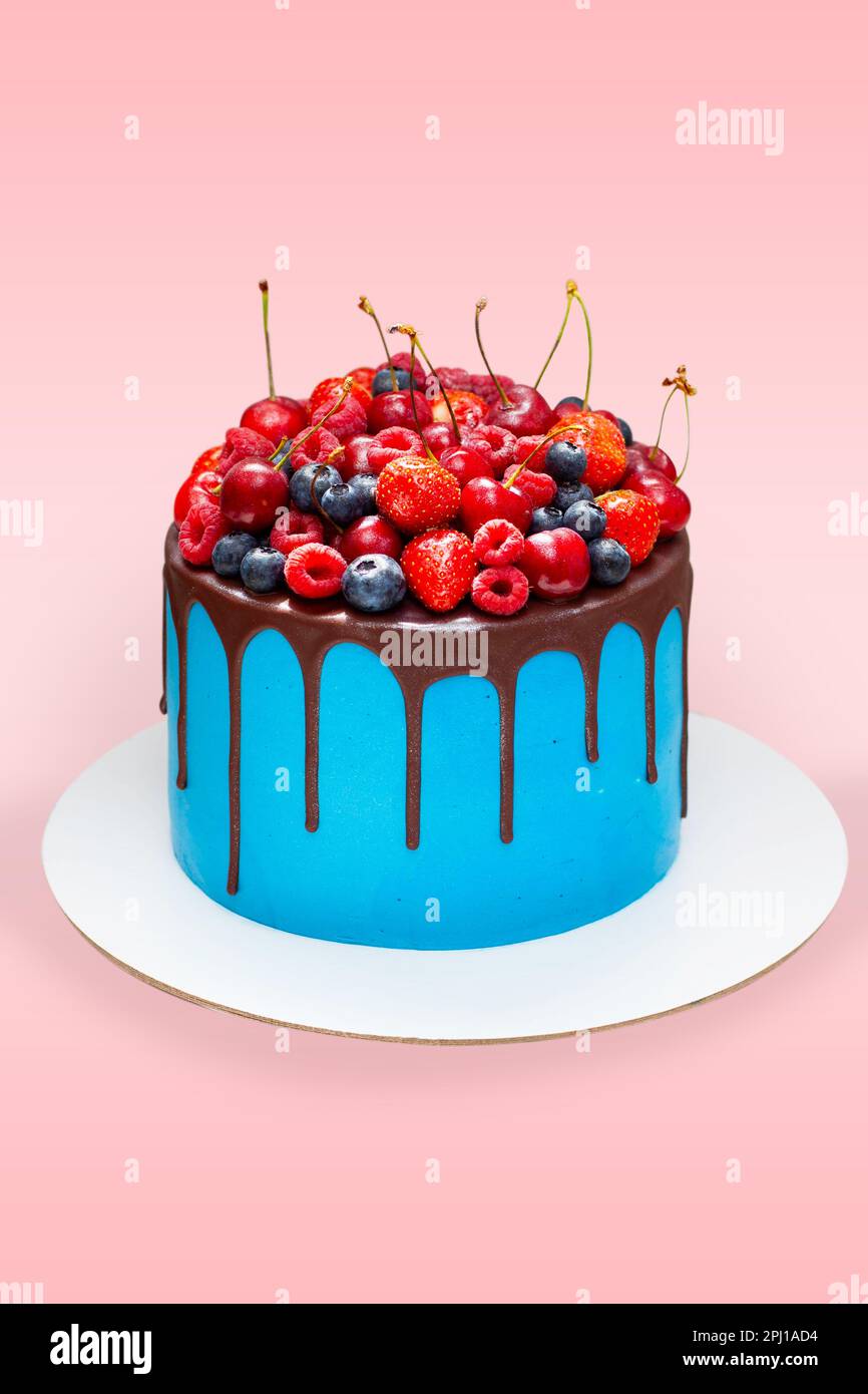 Beautiful blue birthday cake decorated with fresh berries with a place ...