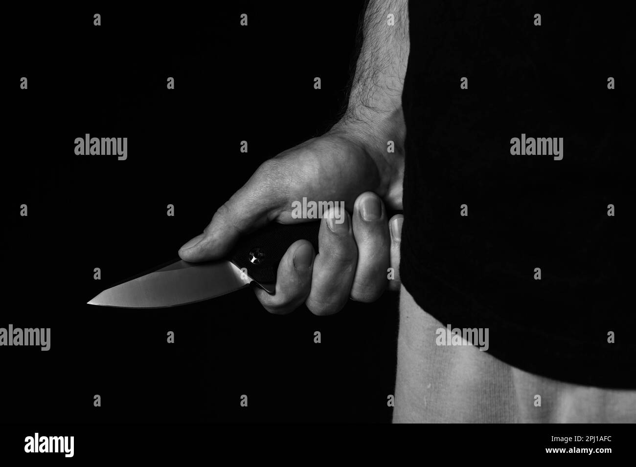 A sharp knife in the man's hand. The use of cold weapons. Knife attack ...