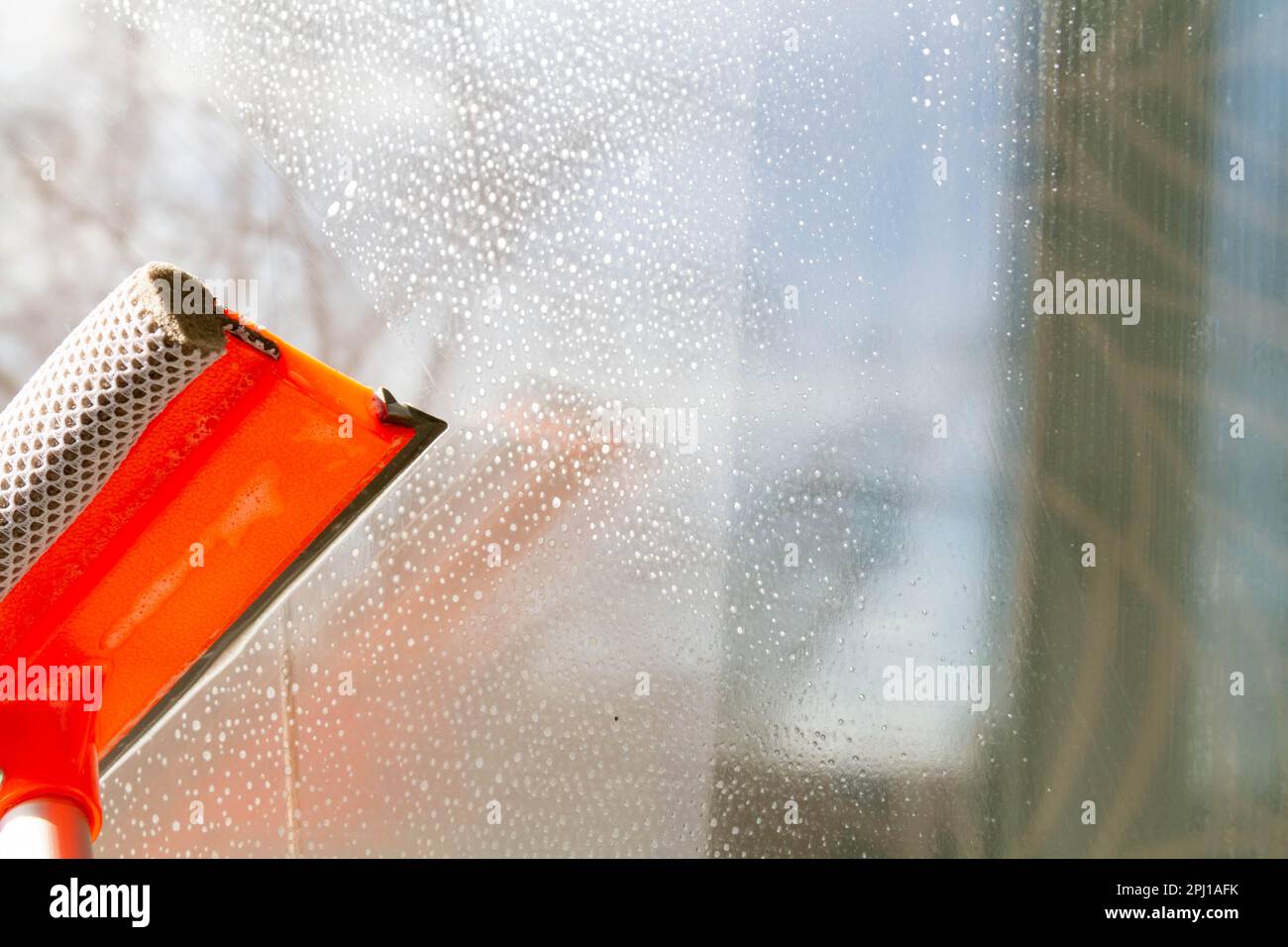 Window washing. Cleaning the window with a brush and foam. The concept ...