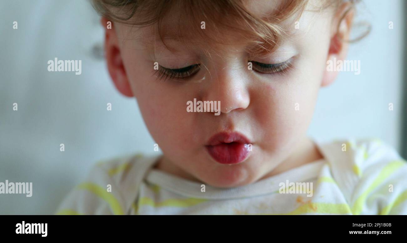 Portrait of baby one year old child eating snack, infant face chewing ...