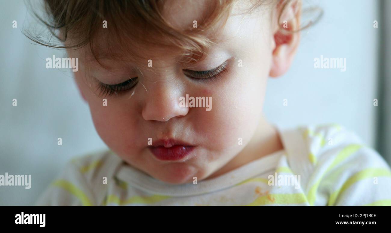 Portrait of baby one year old child eating snack, infant face chewing ...