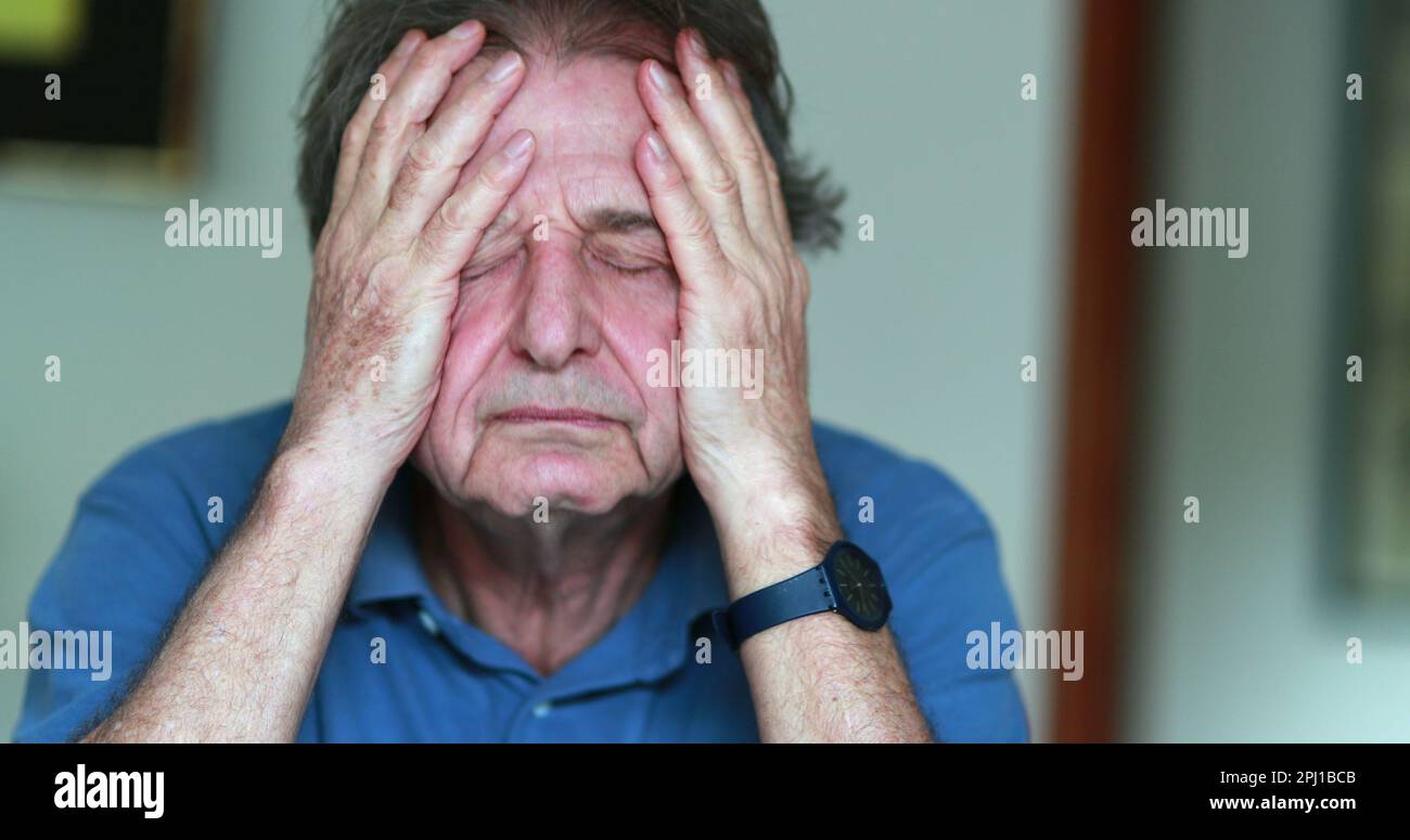Older man covering face with hands, stressed and tired senior man in ...