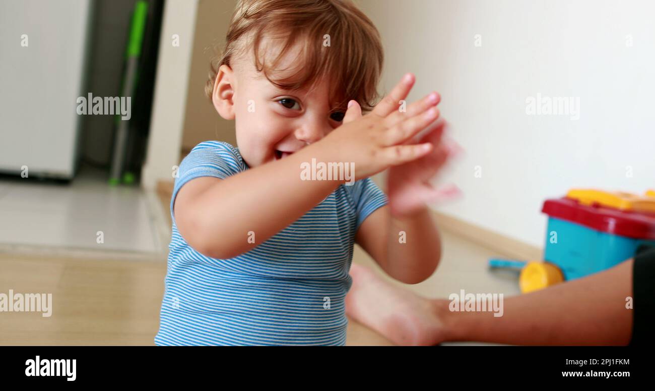 Successful baby clapping hands. One year old infant child solving ...