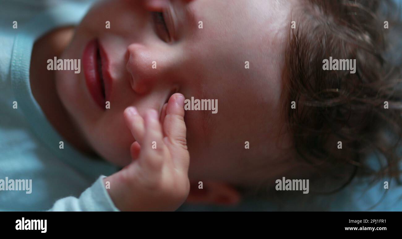Tired baby rubbing eye and face with hands, sleepy child infant Stock Photo - Alamy