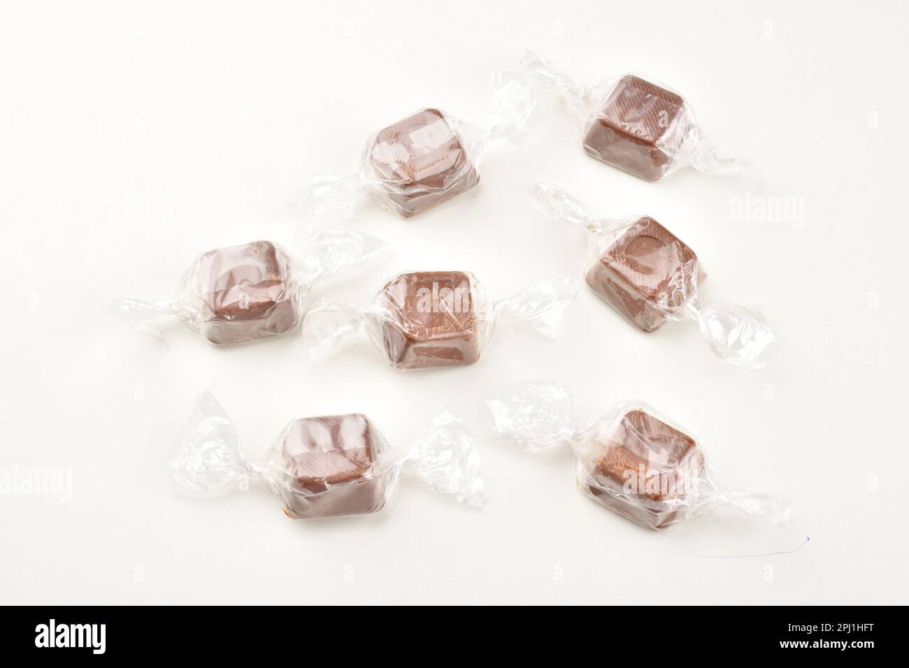 Chocolate candies in plastic wrap on white background Stock Photo - Alamy