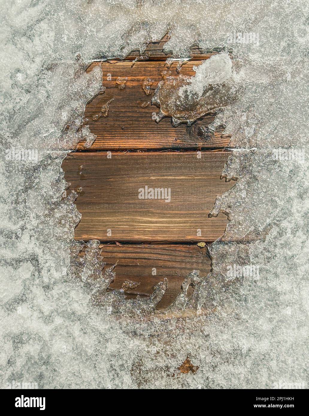 See a thin ice frame with an oval opening showing wet wood slats. The ...
