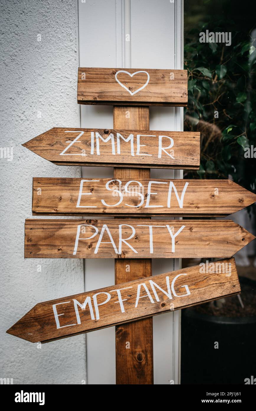 A collection of wooden signs in German: room, eat, party, reception ...