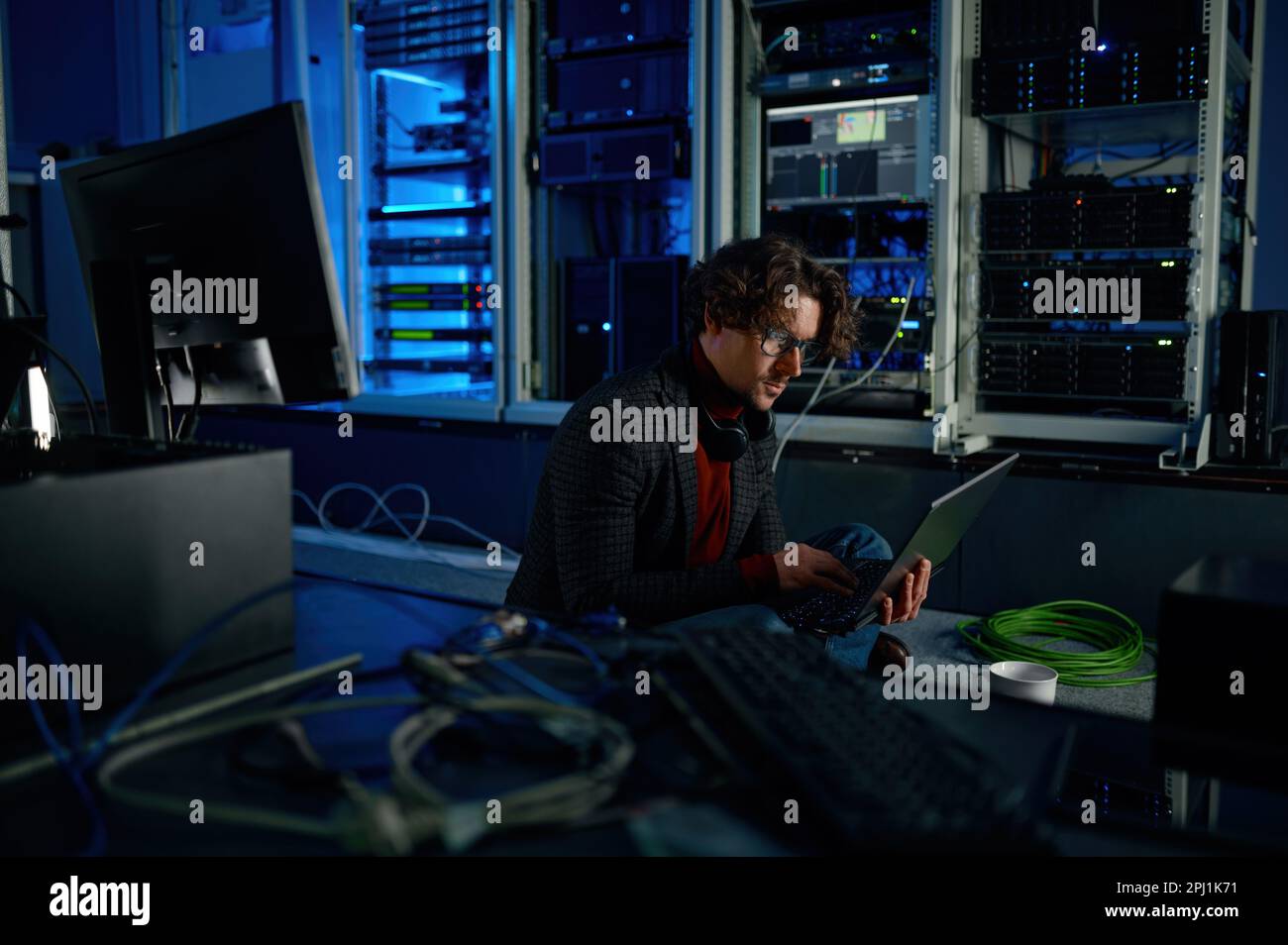 Male system administrator working in server room using laptop Stock ...