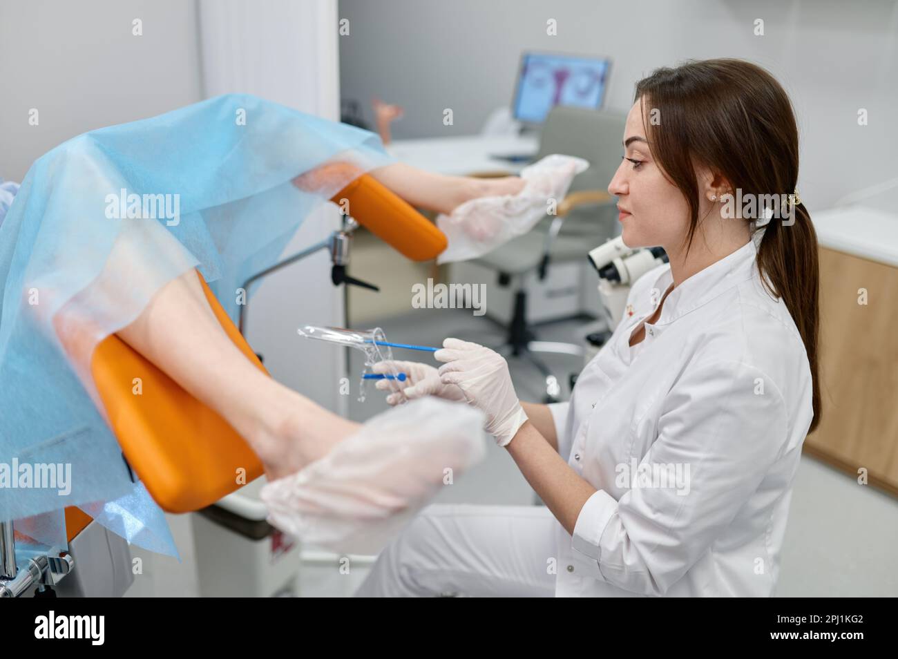 Woman gynecologist taking sample of biomaterial from patient urogenital ...