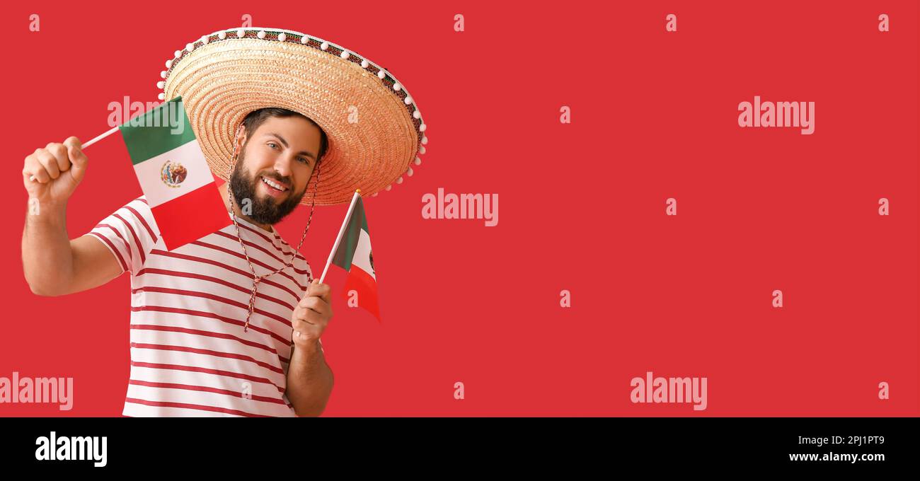 Handsome man in Sombrero and with Mexican flags on red background with ...