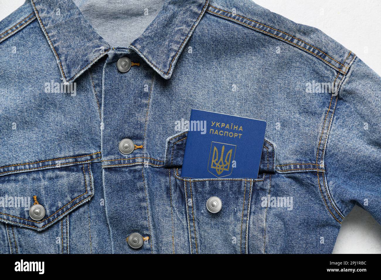 Denim jacket with Ukrainian passport on light background Stock Photo ...