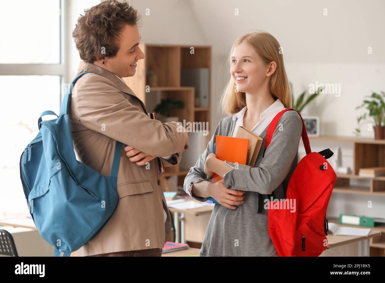 Cute teenage couple with books in classroom Stock Photo - Alamy