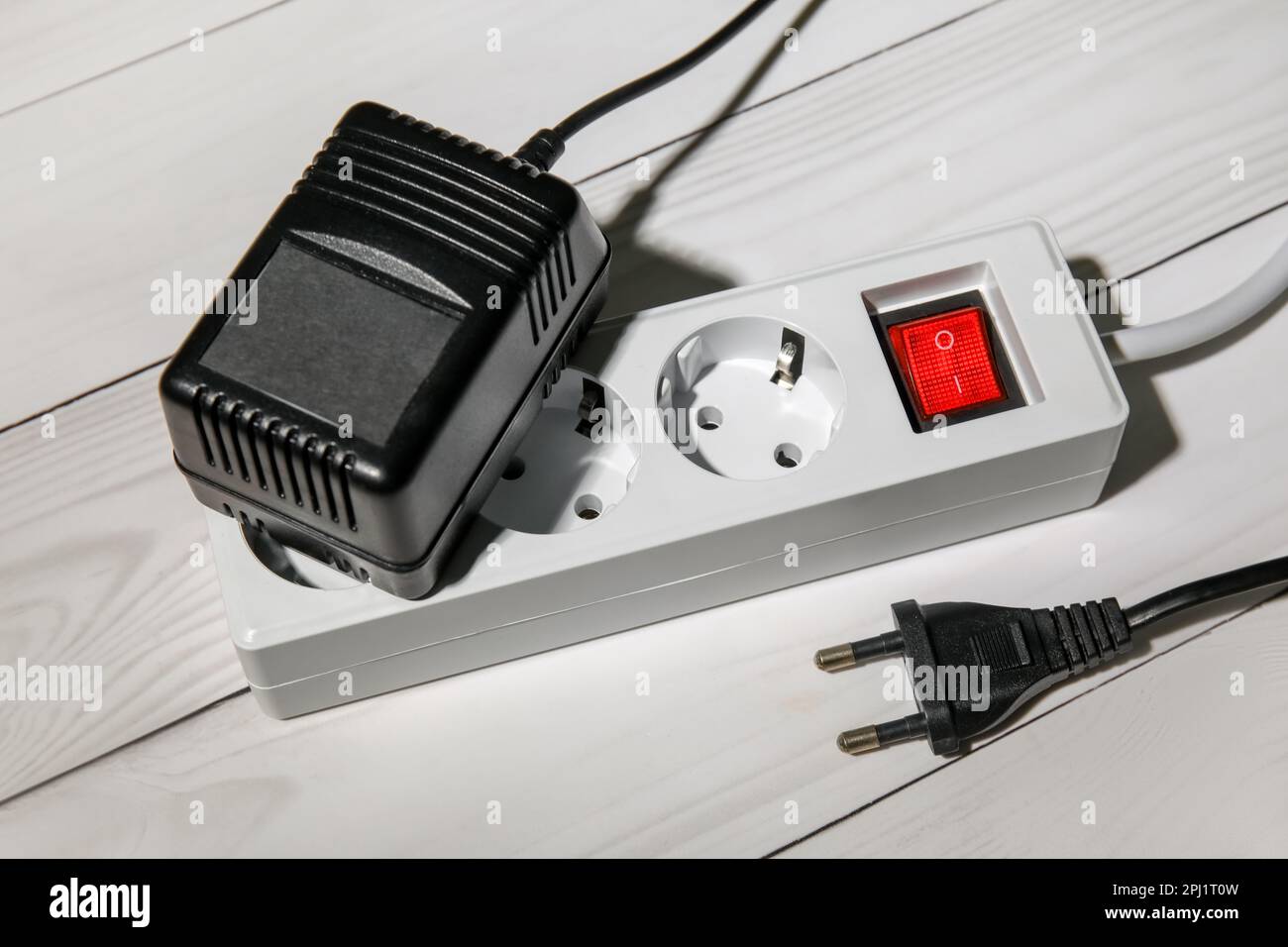 Electric extension cord with plugs on white wooden floor Stock Photo ...