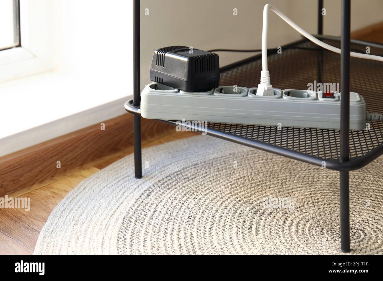 Electric extension cord with plugs on shelf Stock Photo - Alamy