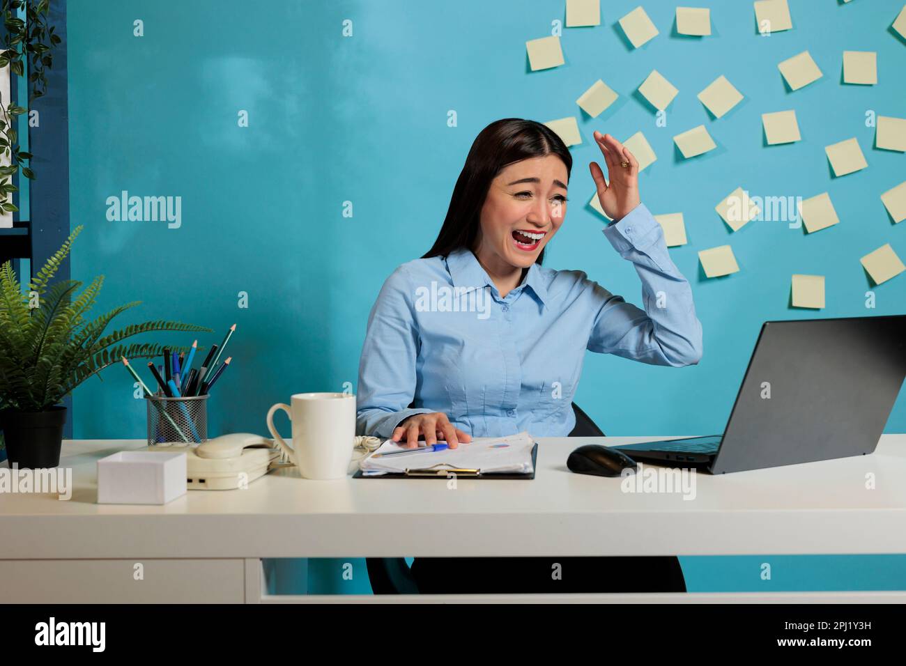 Corporate female employee sitting at modern office desk smiling while ...