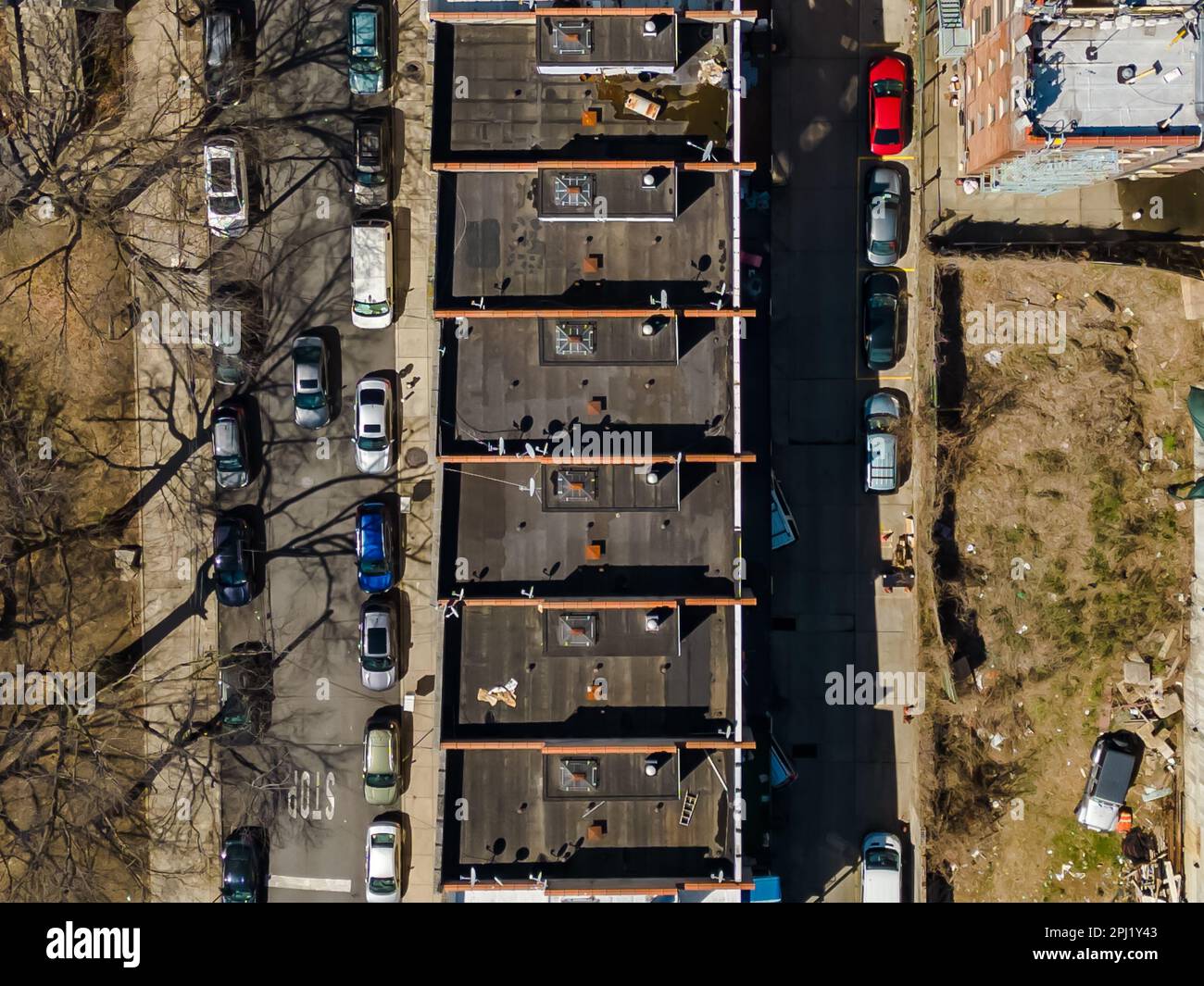 An urban city street with numerous parking spaces and several vehicles ...