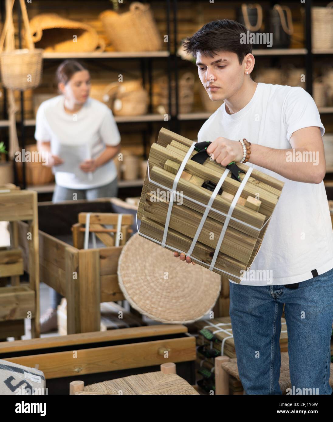 guy choose folding wooden furniture for country house in store Stock ...