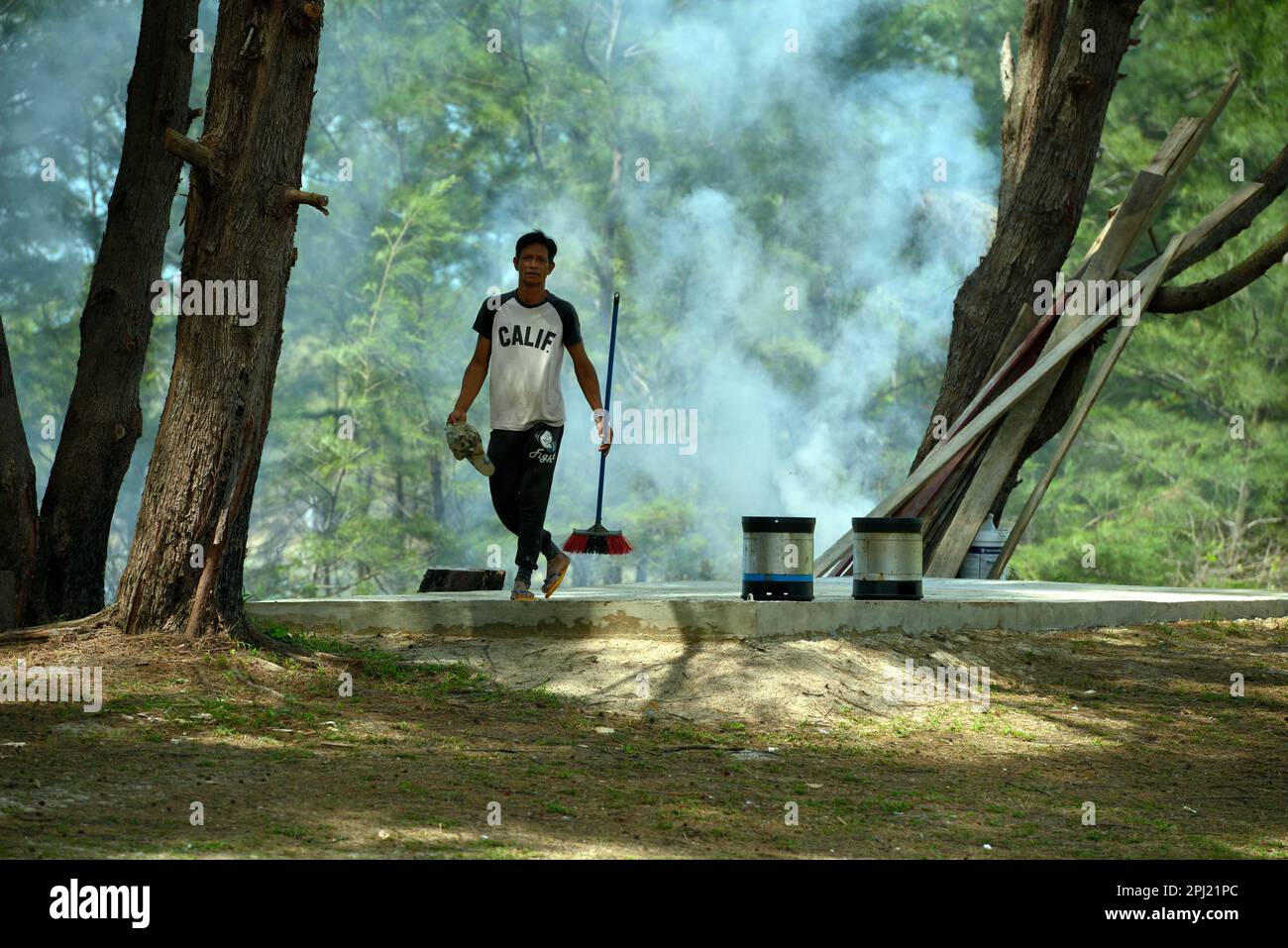 A man burning garbage by the beach at the Tip of Borneo, Malaysia Stock ...