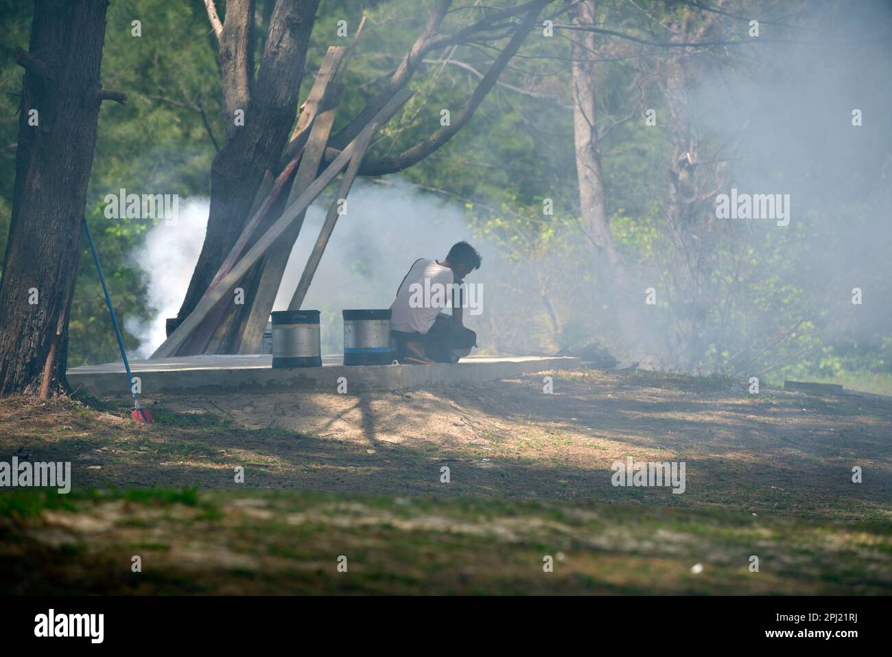 A man burning garbage by the beach at the Tip of Borneo, Malaysia Stock ...