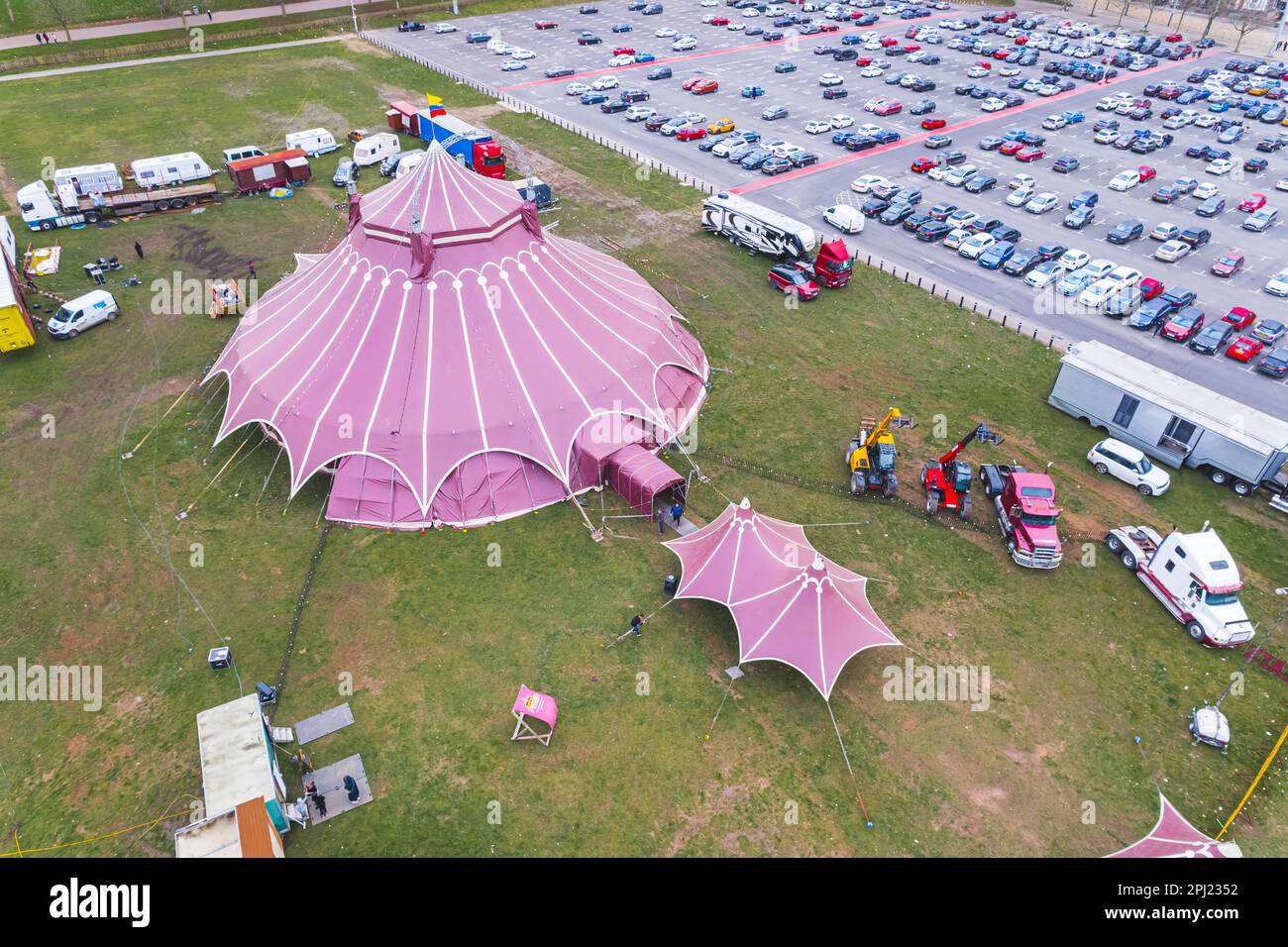Red circus tent seen from aerial perspective standing on a grass field ...