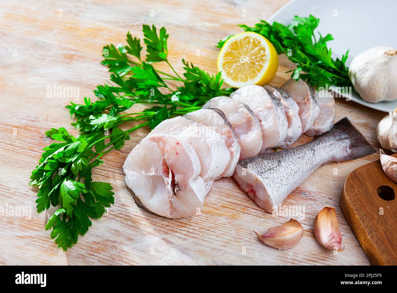 Raw steaks of hake with lemon and greens ready for cooking Stock Photo ...