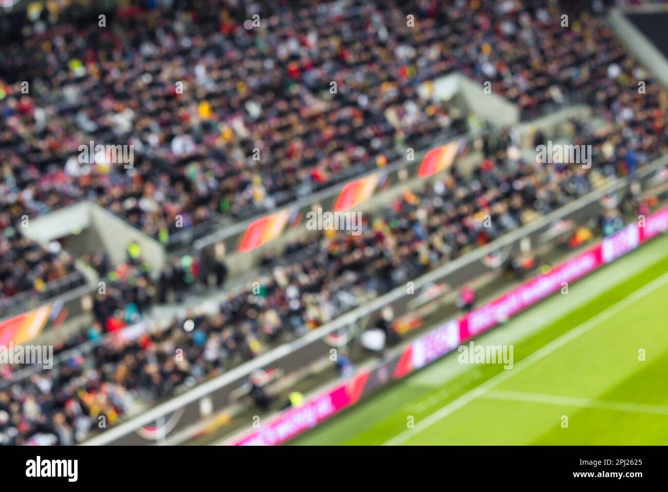 out of focus image of a crowd of people on a grandstand in a soccer ...