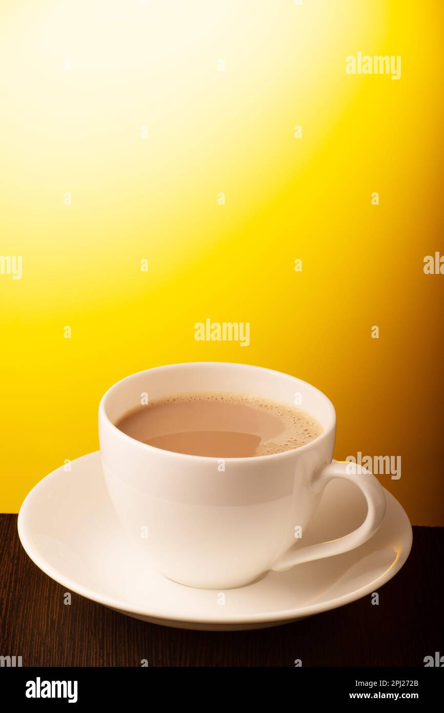 Cup of milk tea on yellow background Stock Photo - Alamy
