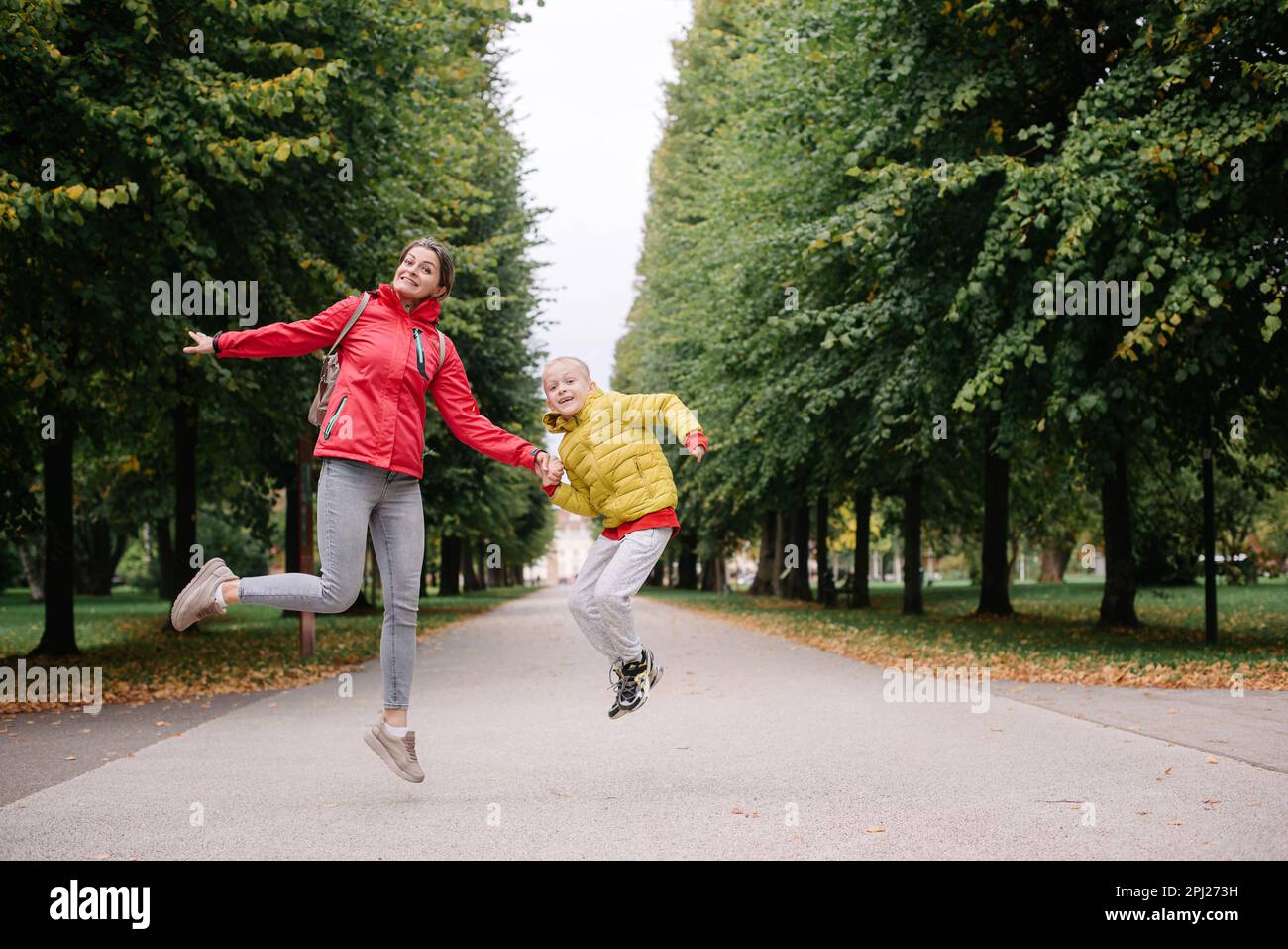 Mother and son jumping in the autumn park. Fall Season. Happy young ...