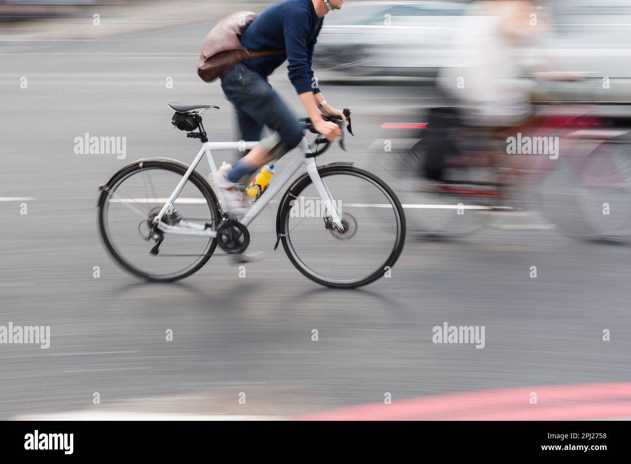 picture with intentional motion blur effect of a man on a racing bike in the city traffic Stock ...