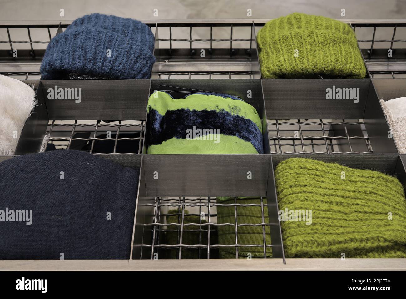 Knitted warm winter clothes on the shelf in the store Stock Photo - Alamy