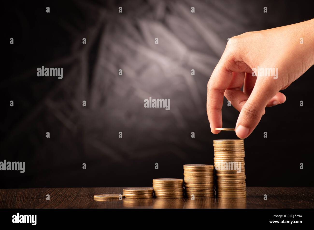 Hand putting coin stack money investment concept Stock Photo - Alamy