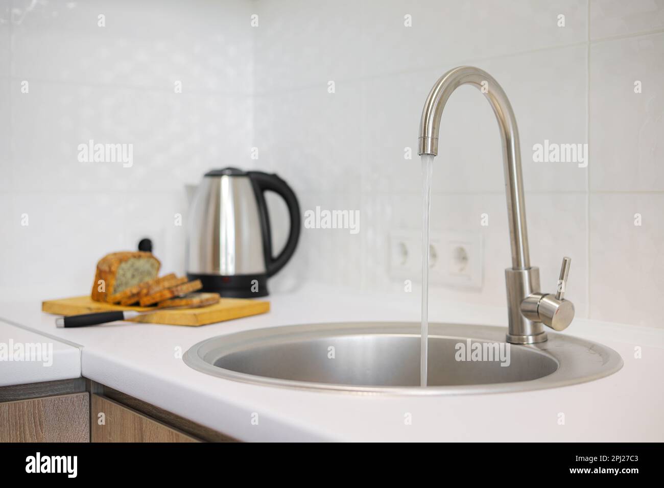 Faucet and steel sink close-up in the kitchen Stock Photo - Alamy