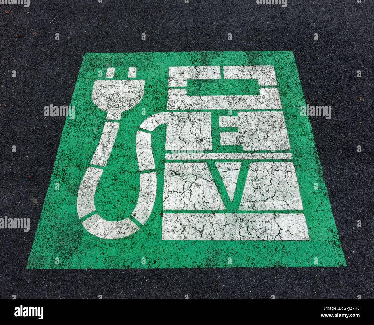 Electric vehicle charge sign painted on the tarmac in a car park ...