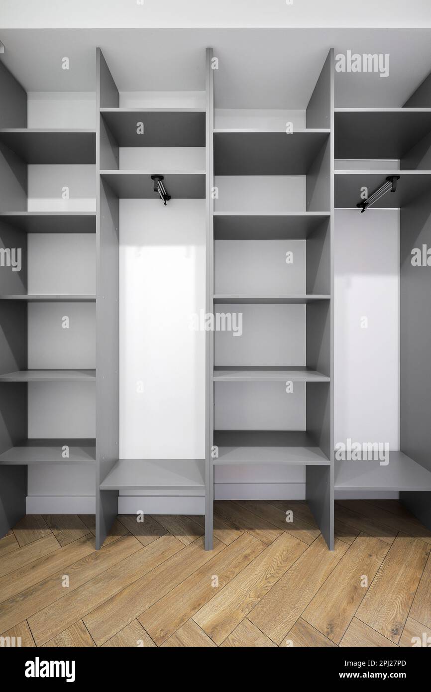 Open grey wardrobe with shelves in the room Stock Photo - Alamy