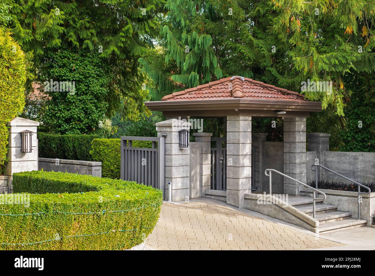 Iron front gate of a beautiful luxury home with landscaping. Gateway of ...