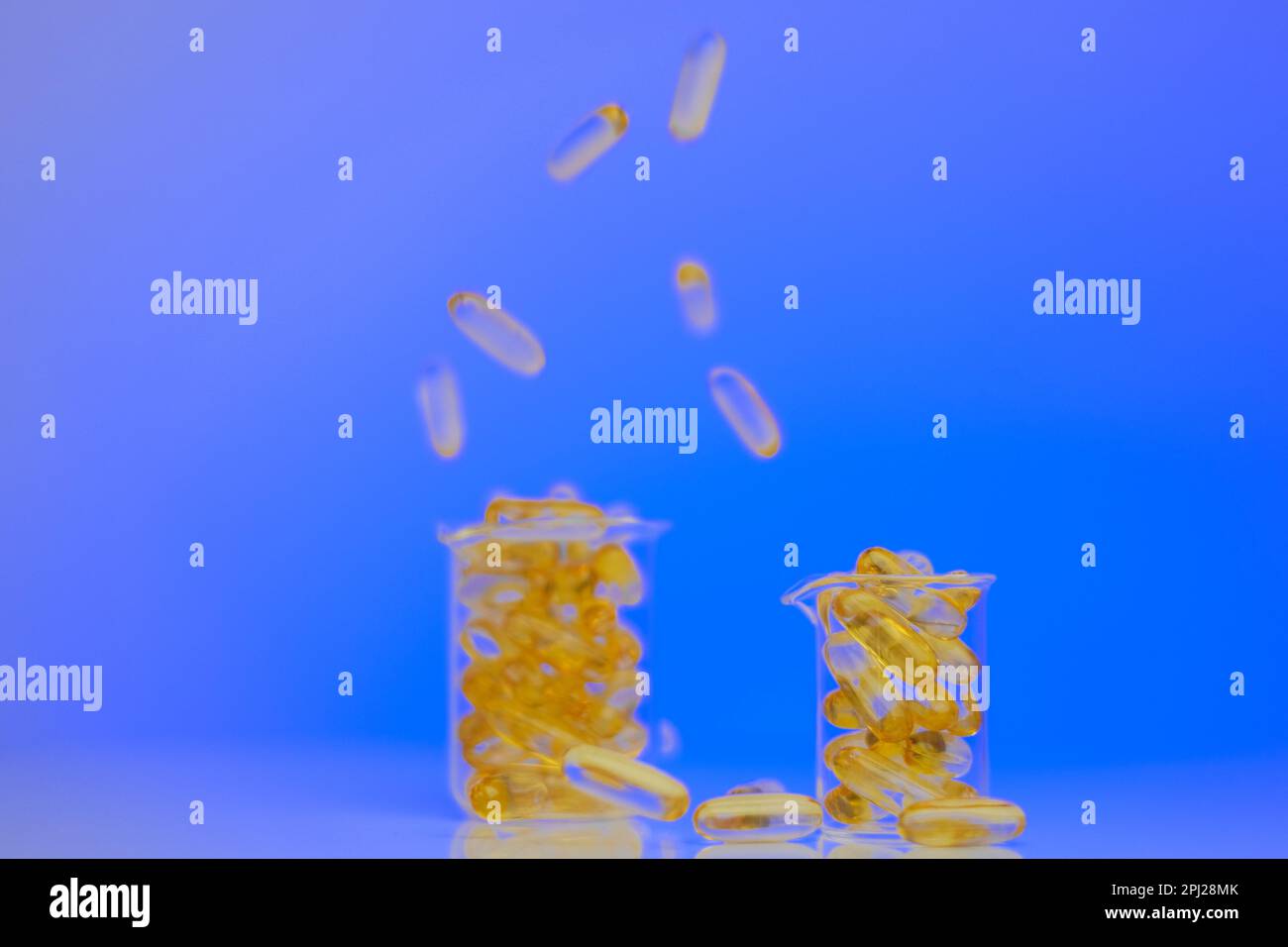 Yellow omega fatty acids oil capsules in transparent containers on a ...