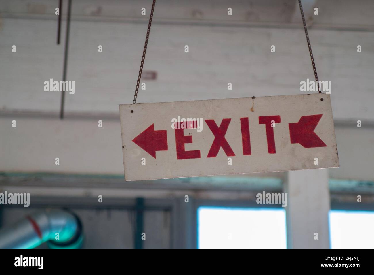 Old Exit Sign Hanging From The Ceiling Of An Abandoned Factory Stock