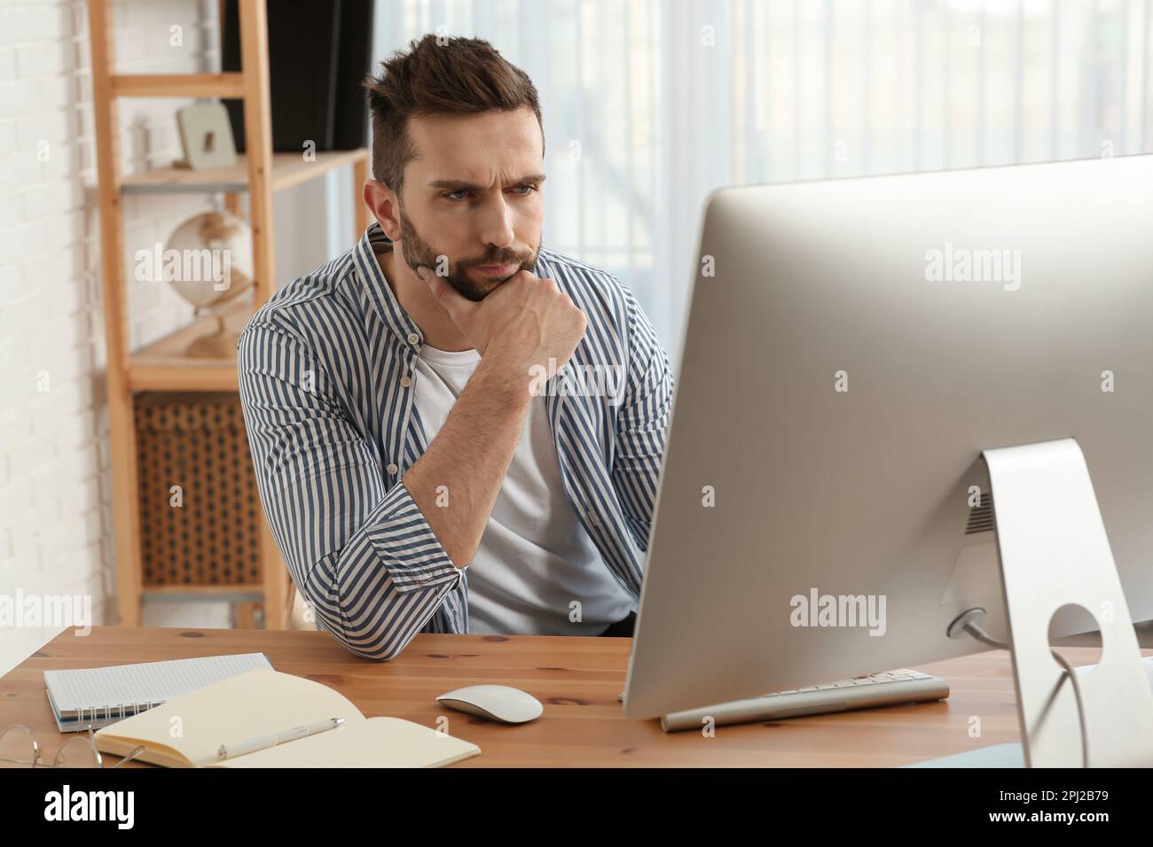 Online test. Man studying with computer at home Stock Photo - Alamy