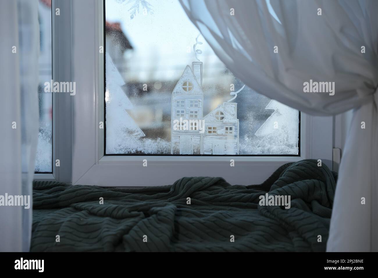 Beautiful drawing made of artificial snow on window at home. Christmas ...