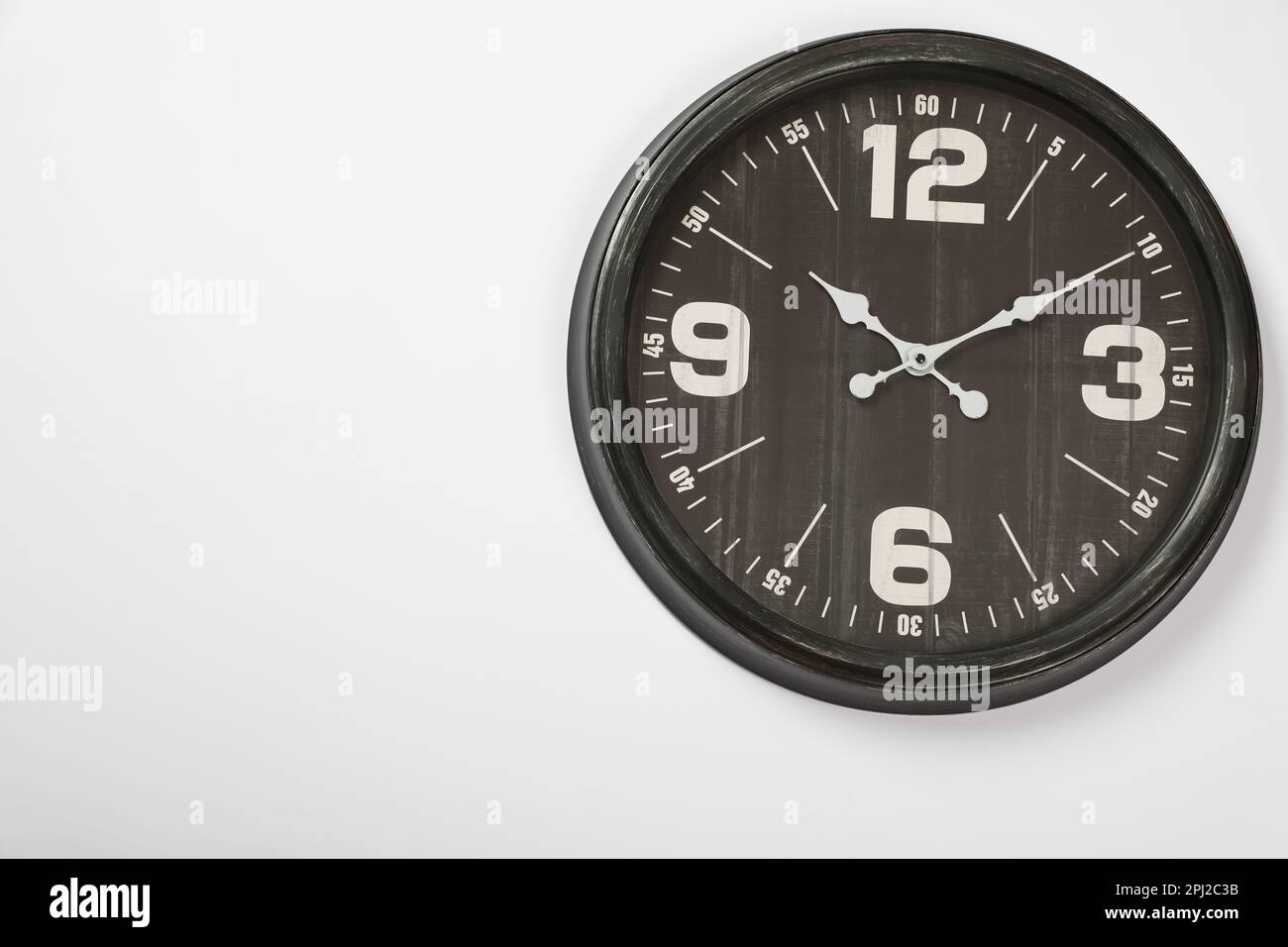 Stylish analog clock hanging on white wall, space for text Stock Photo ...